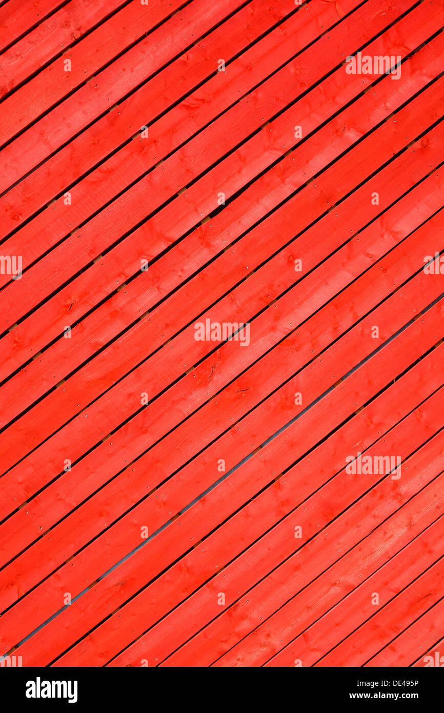 Red stained sawn timber slats on a modern building viewed diagonally to ...
