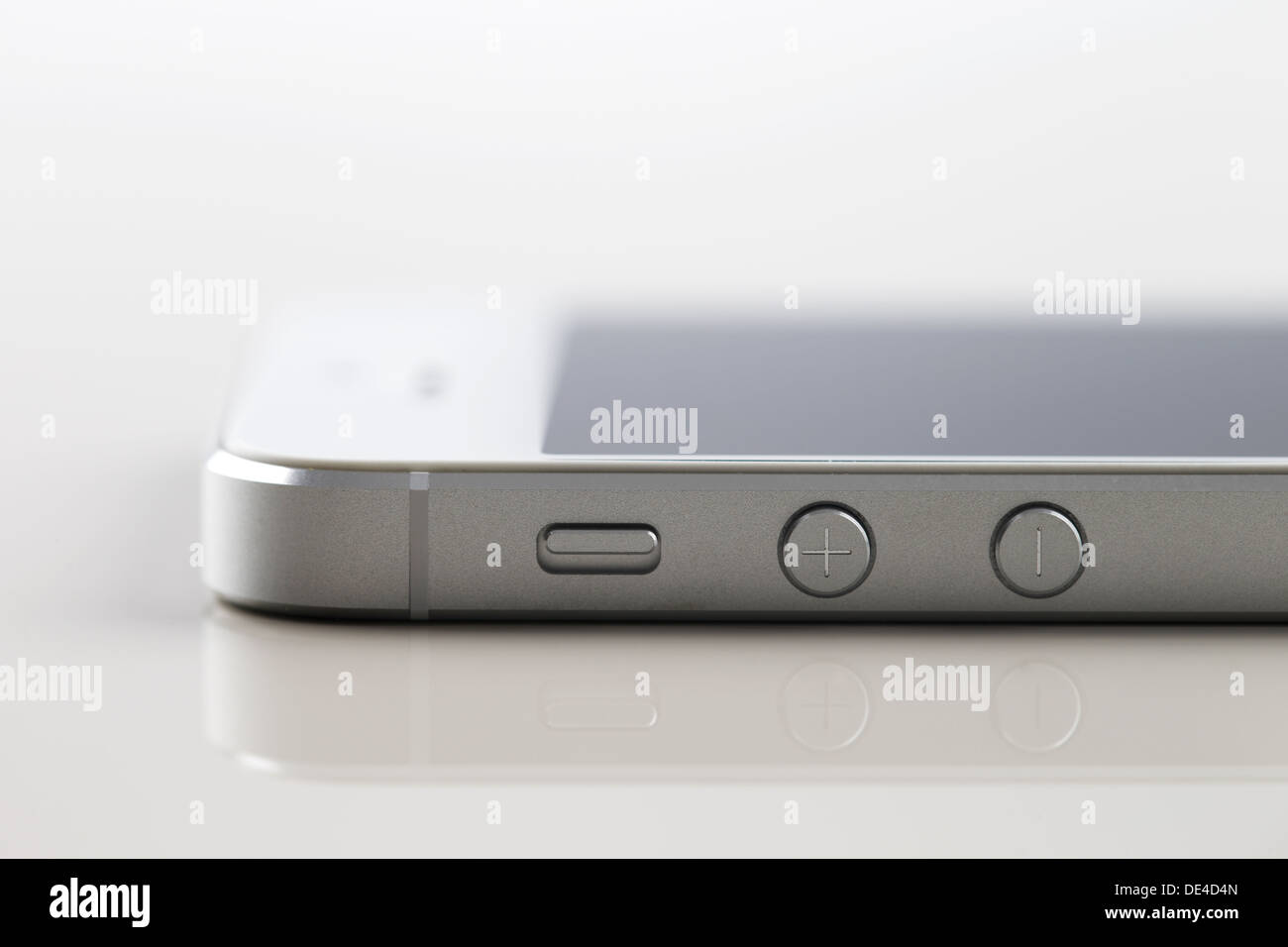 A close-up of a new white smartphone on a white reflective background ...