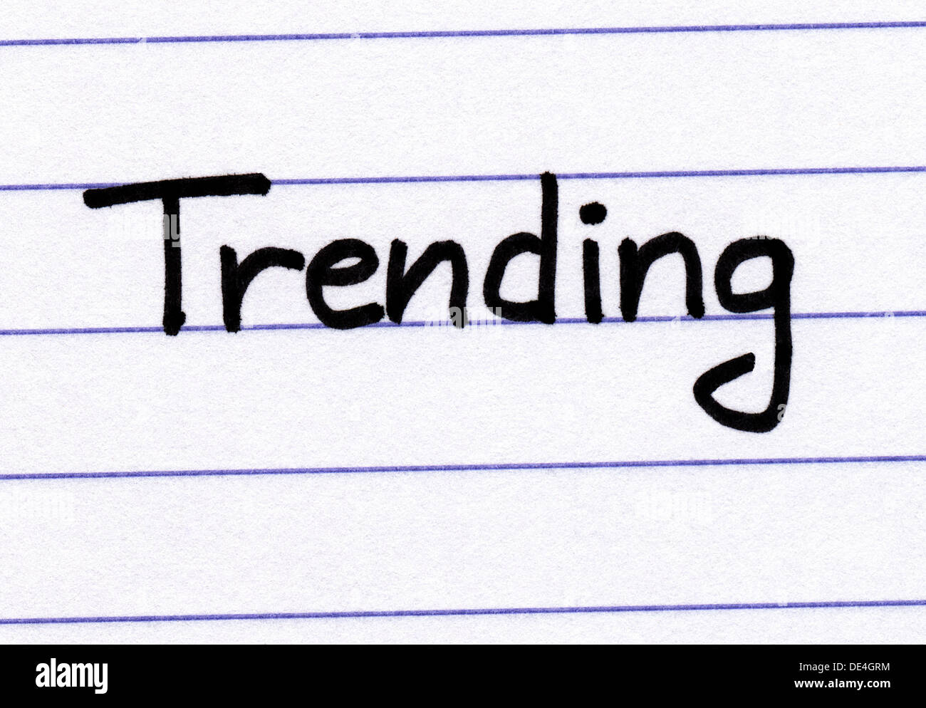 Trending written in black ink on white lined paper Stock Photo - Alamy