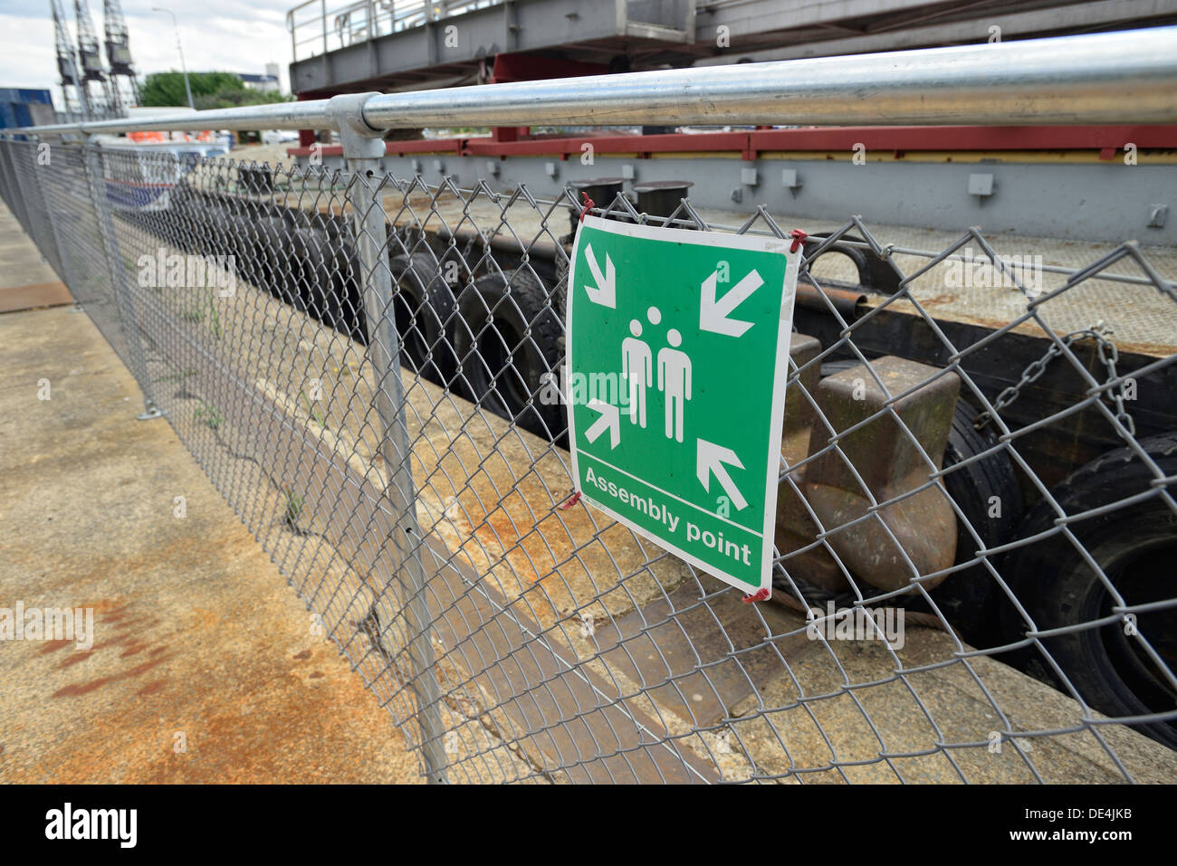 Assembly point sign on a metal fence Stock Photo - Alamy