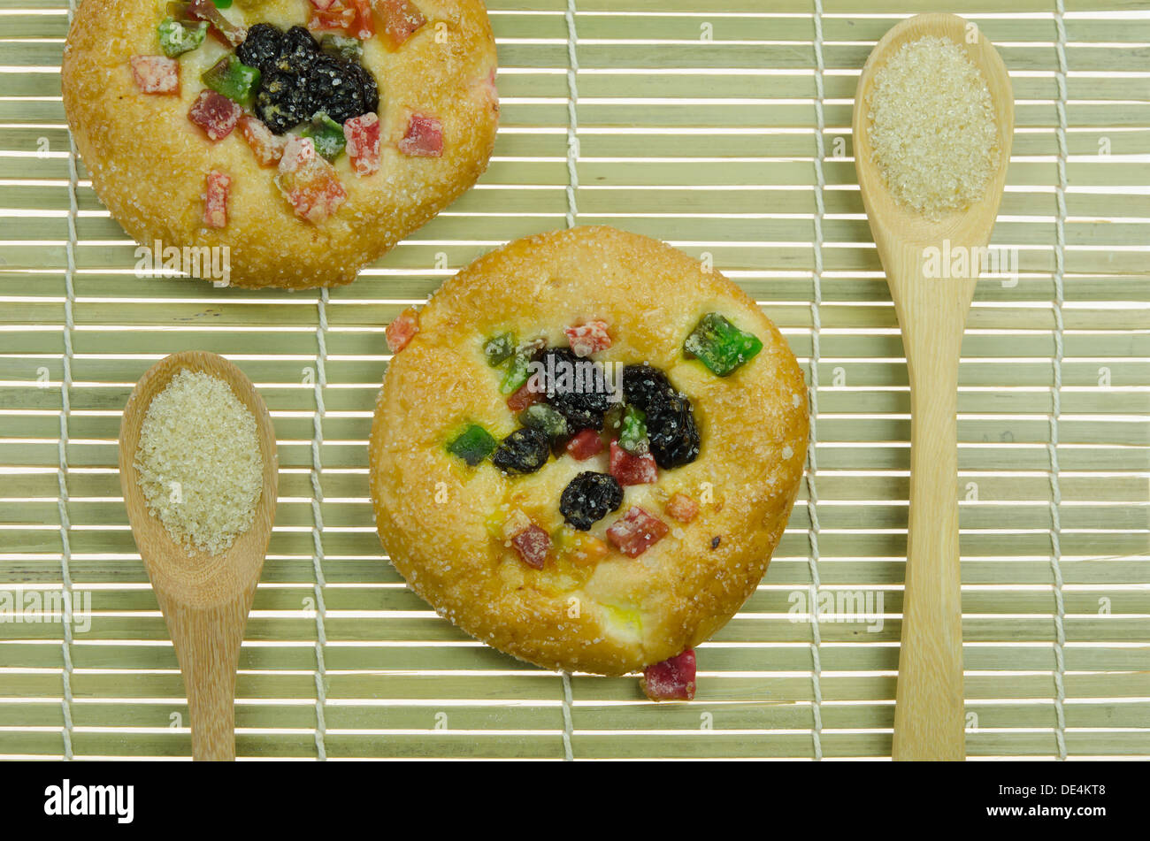 two sweet bread with raisin and dried fruits and two spoon of sugar on ...