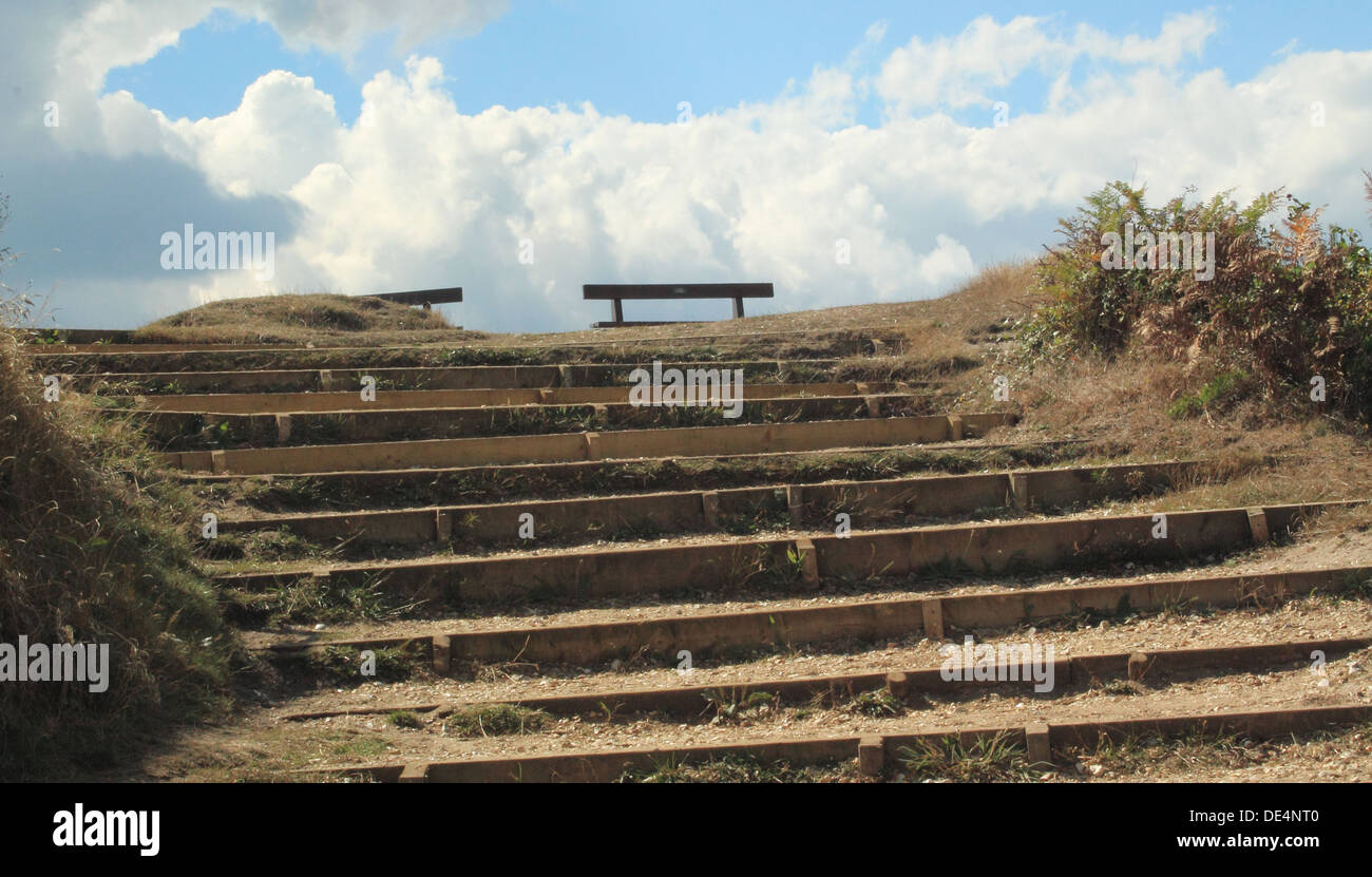 A long, winding, natural staircase leading to a pair of benches ...