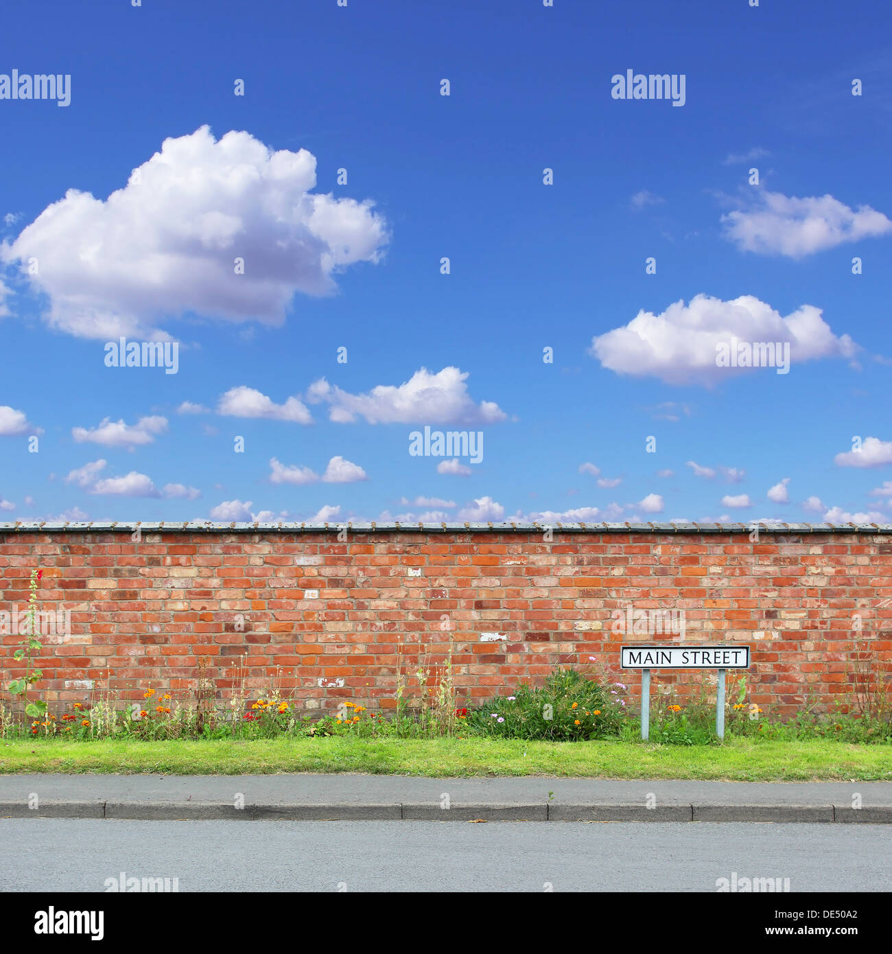 Red Brick Wall with a Main Street Sign and Sidewalk Stock Photo - Alamy