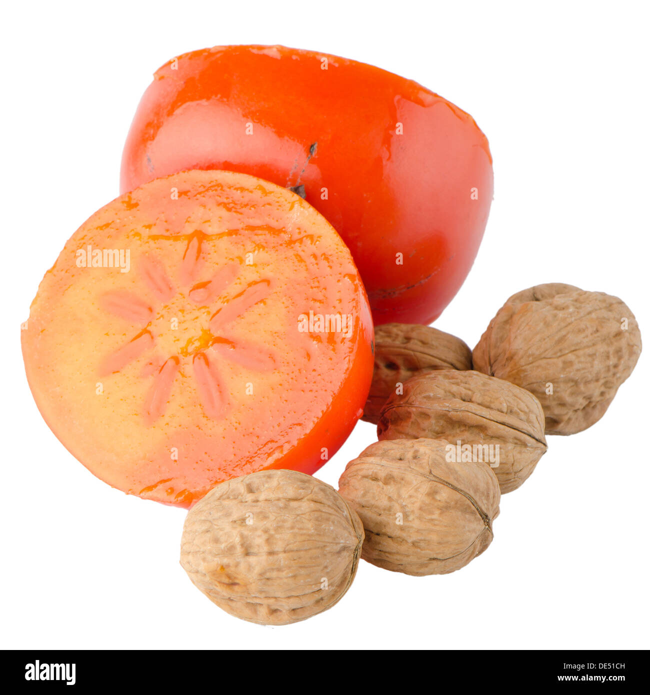 Ripe persimmons and nuts on white background Stock Photo - Alamy