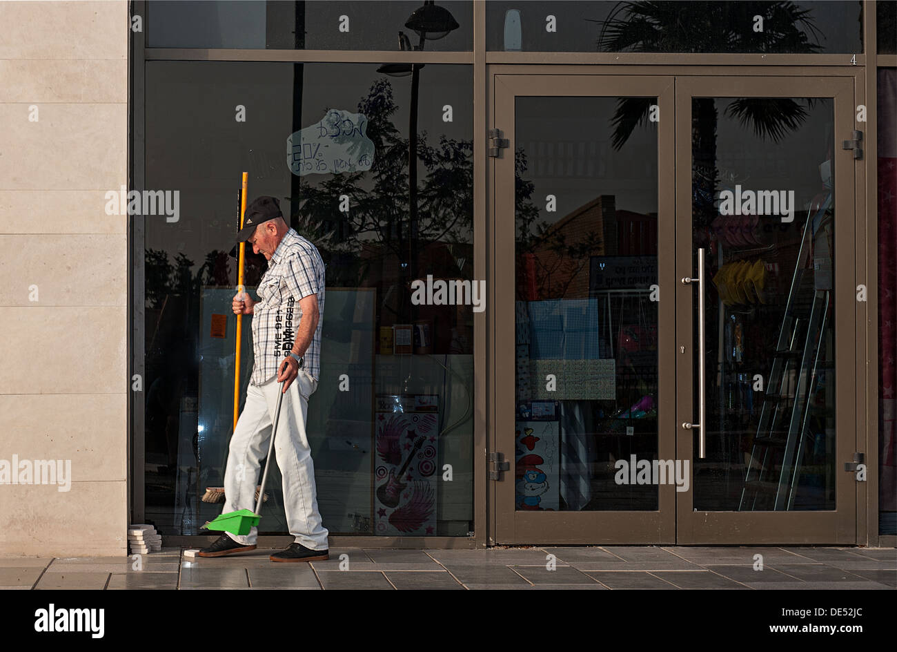 A cleaning worker cleans & sweep a market square in Mazkeret Batya ...