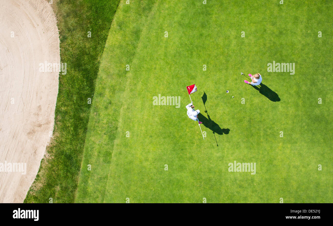 Two golfers on a green, putting Stock Photo - Alamy