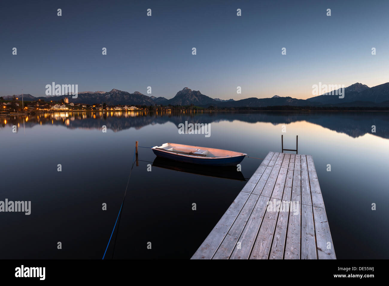 Evening light at Hopfensee Lake with jetty and rowing boat, Allgaeu ...