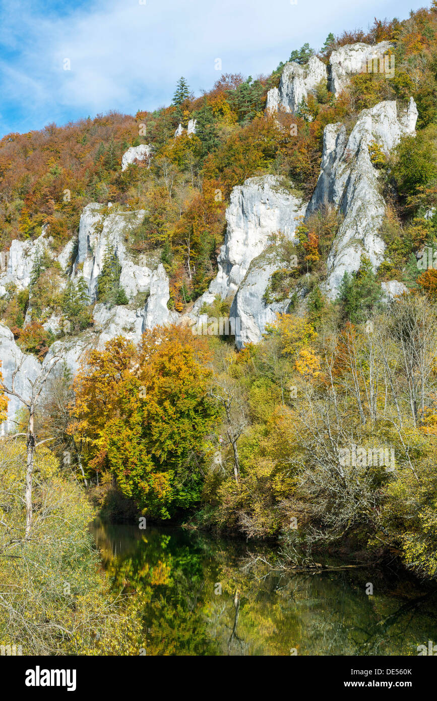 Craggy limestone rocks with a deciduous forest with autumnal colours ...