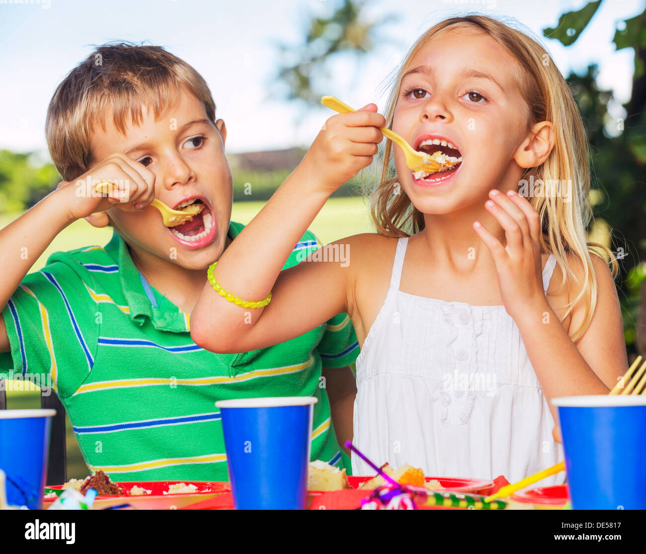 Happy Young Boy and Girl Eating Cake at Birthday Party Stock Photo - Alamy