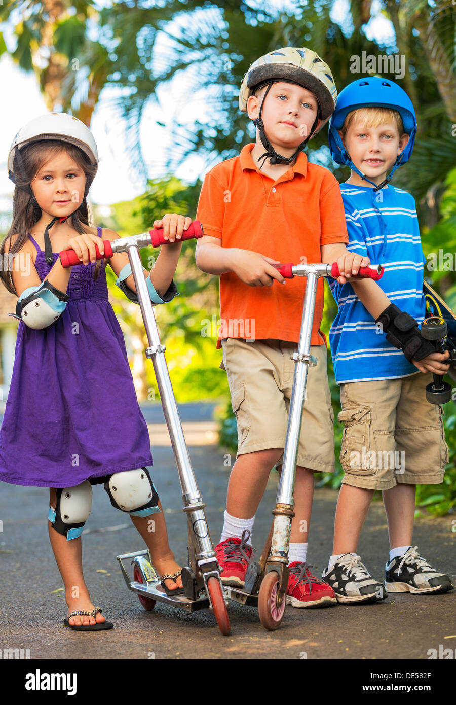 Group of Neighborhood Kids with Skateboards and Scooters Playing Stock ...