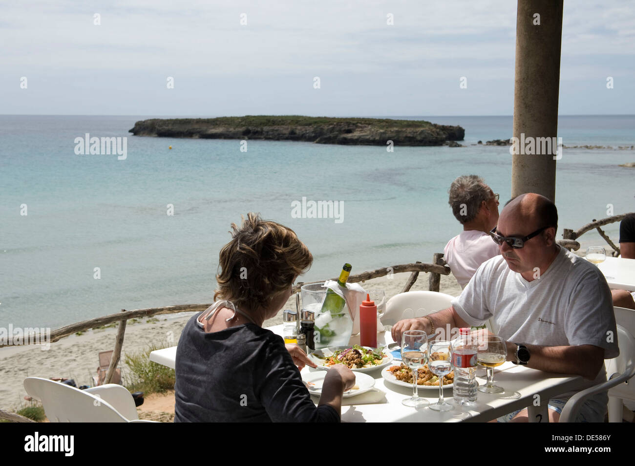 Tourists chill or sunbath in the beach in the Spanish Balearic islands ...