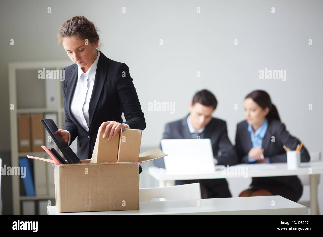 Portrait of smart businesswoman packing her things on background of ...
