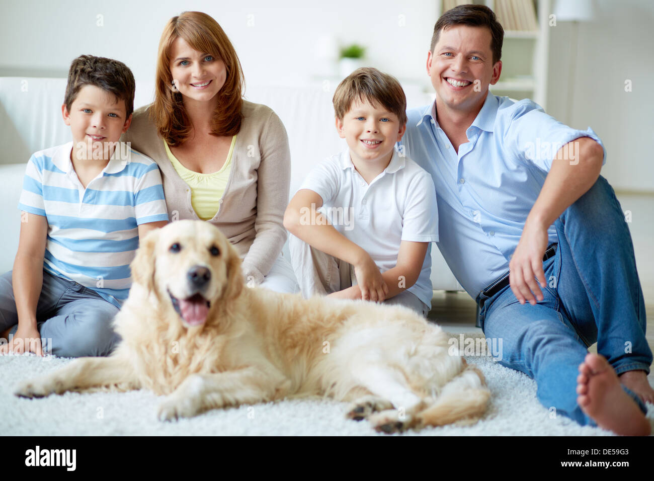 Portrait of happy family with their pet having rest at home Stock Photo ...