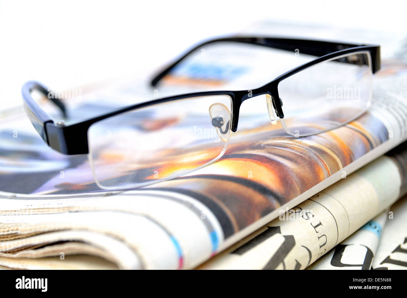 Stack of newspapers with glasses on top Stock Photo - Alamy