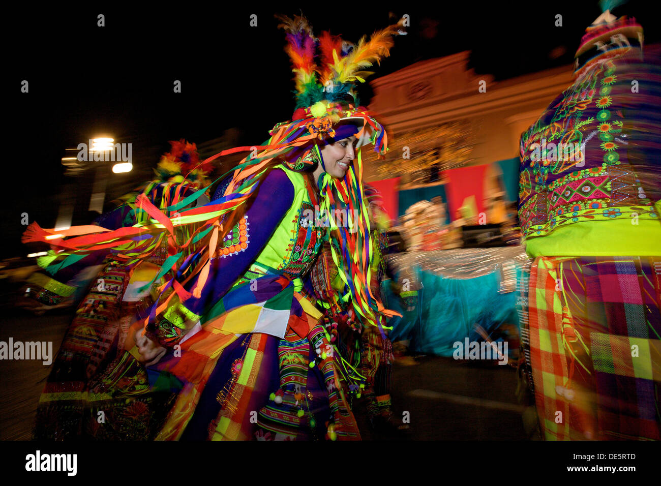 A costumed reveler from Bolivia dances in the streets during the ...