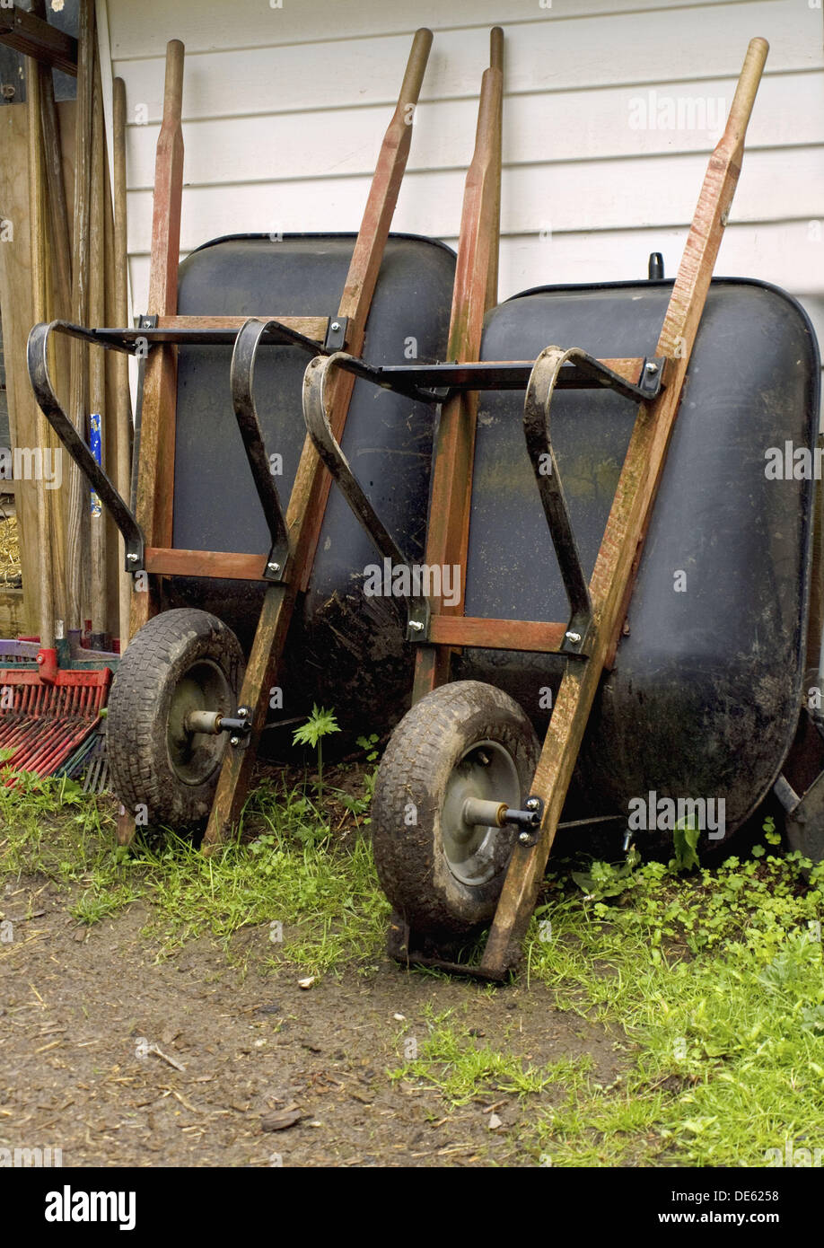 Wheelbarrows leaning up against the barn wall Vertical Two Stock Photo ...