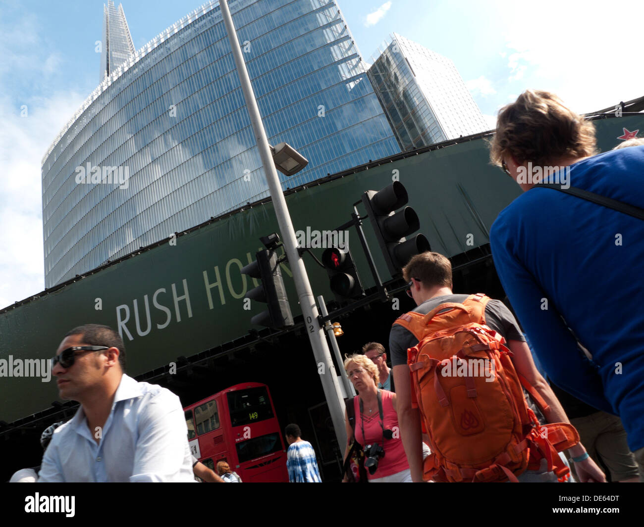 Rush Hour sign on hoarding above pedestrians in street at London Bridge ...