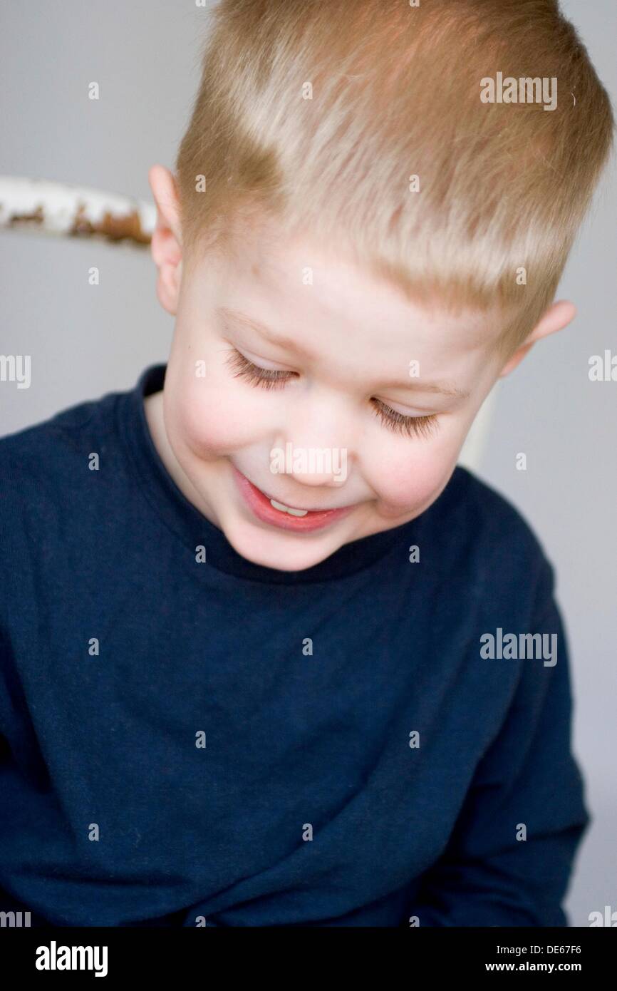A young child smiling and looking down Stock Photo - Alamy