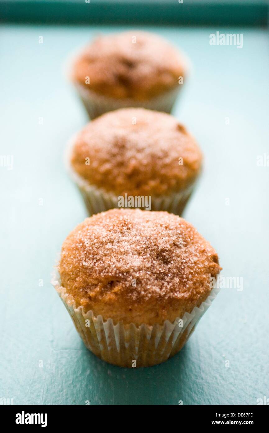 Fresh, sugar-topped muffins in a row on a blue tray Stock Photo - Alamy