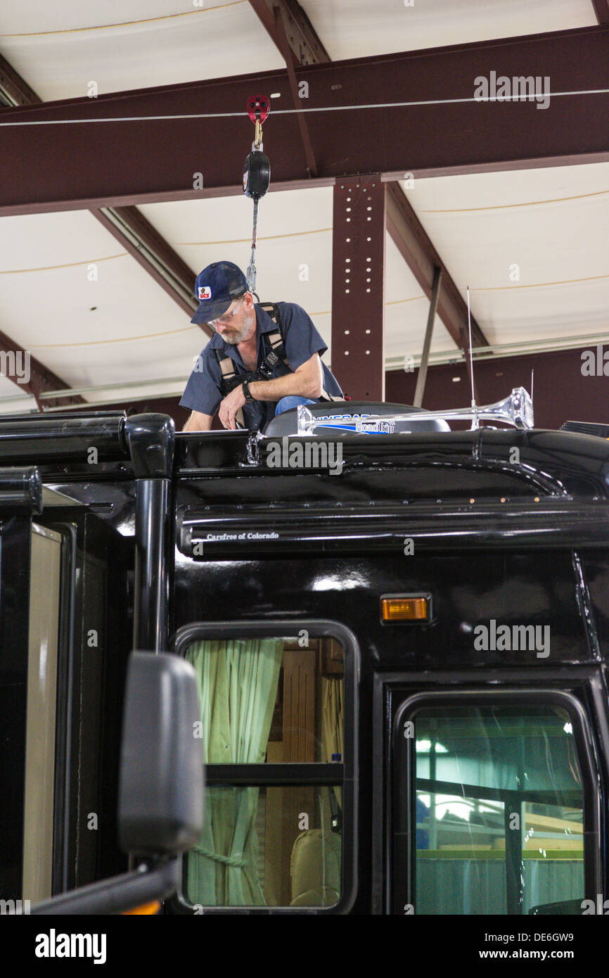 Man tethered to overhead safety harness working on the roof of a ...
