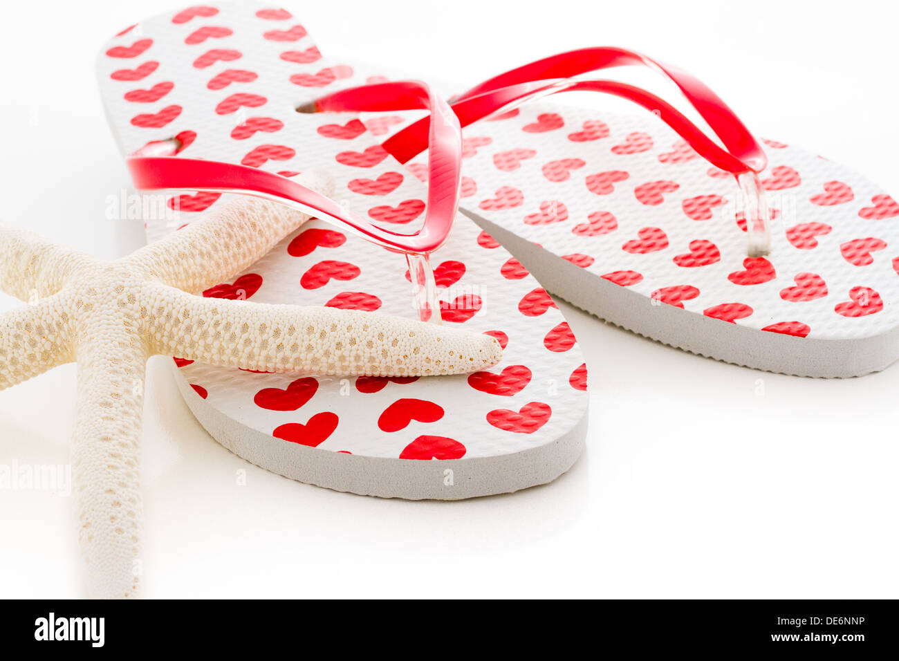 Star sea shell with flip flops on a white background Stock Photo - Alamy