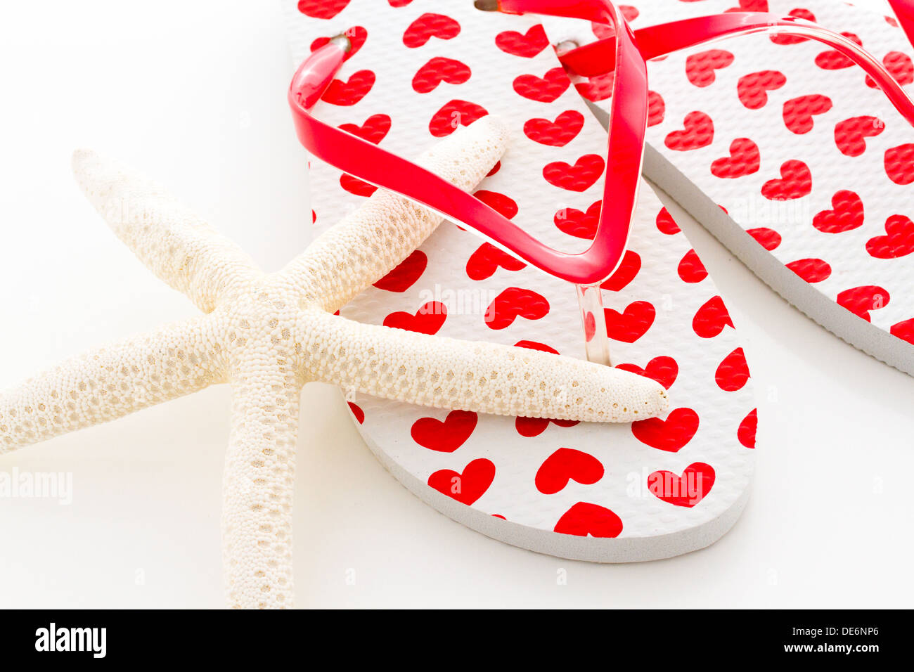 Star sea shell with flip flops on a white background Stock Photo - Alamy