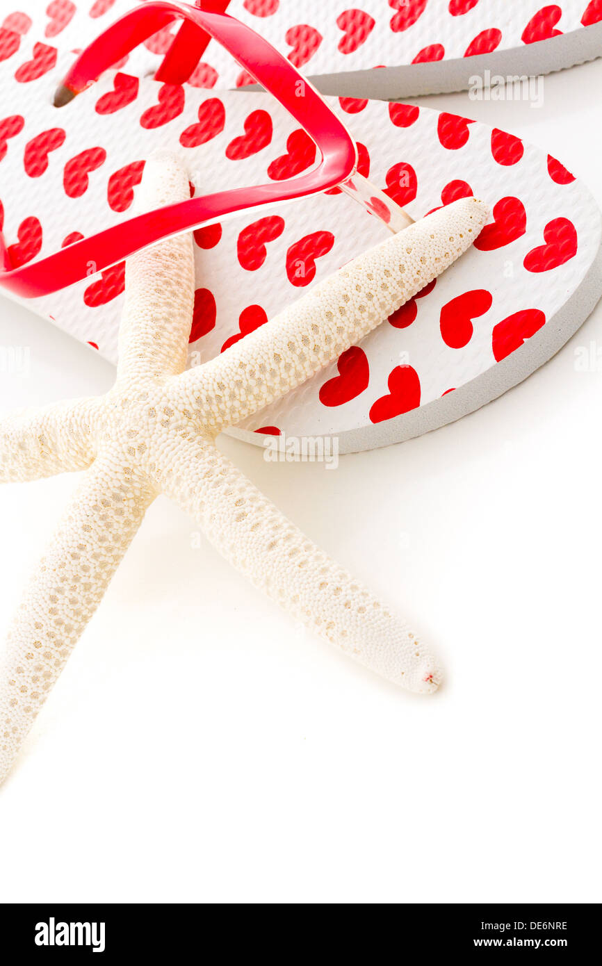 Star sea shell with flip flops on a white background Stock Photo - Alamy