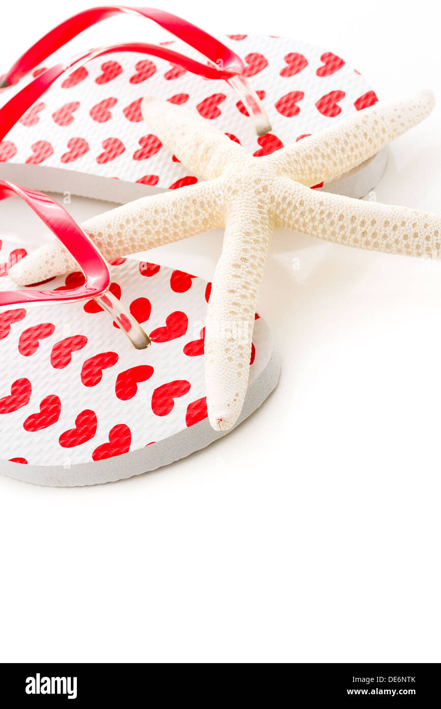 Star sea shell with flip flops on a white background Stock Photo - Alamy