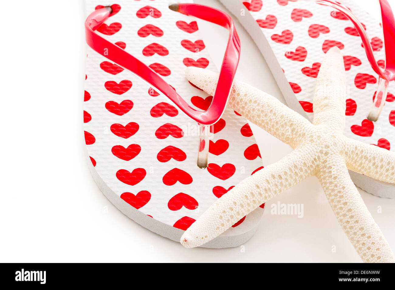 Star sea shell with flip flops on a white background Stock Photo - Alamy