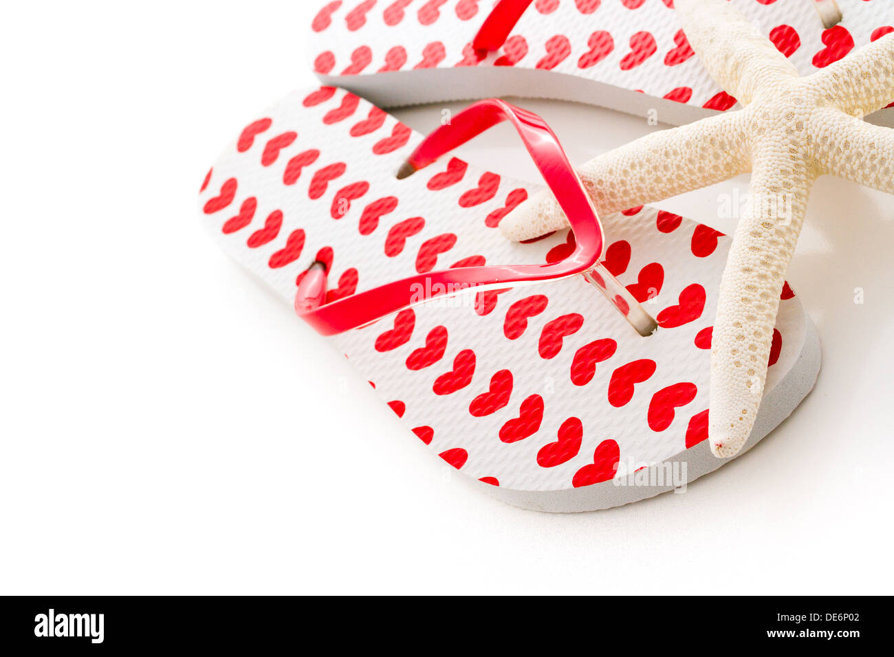 Star sea shell with flip flops on a white background Stock Photo - Alamy