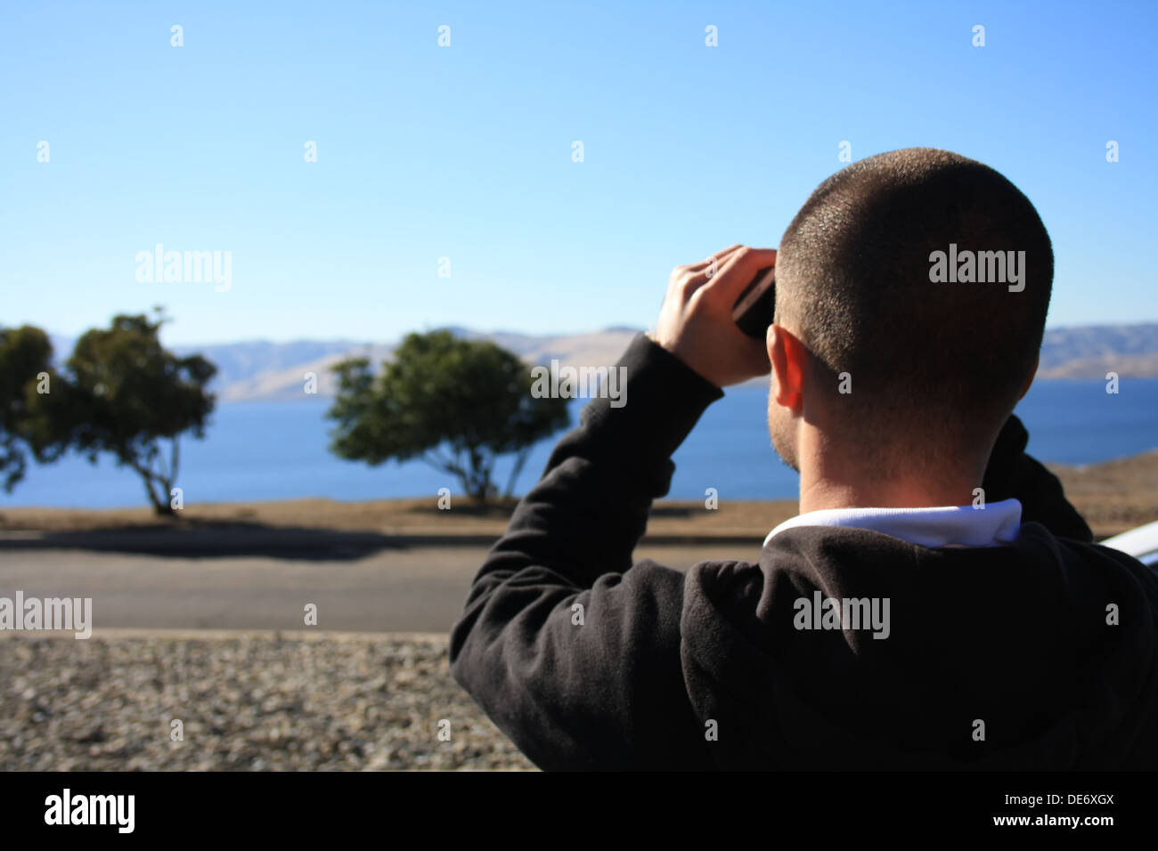 Man behind tree binoculars hi-res stock photography and images - Alamy