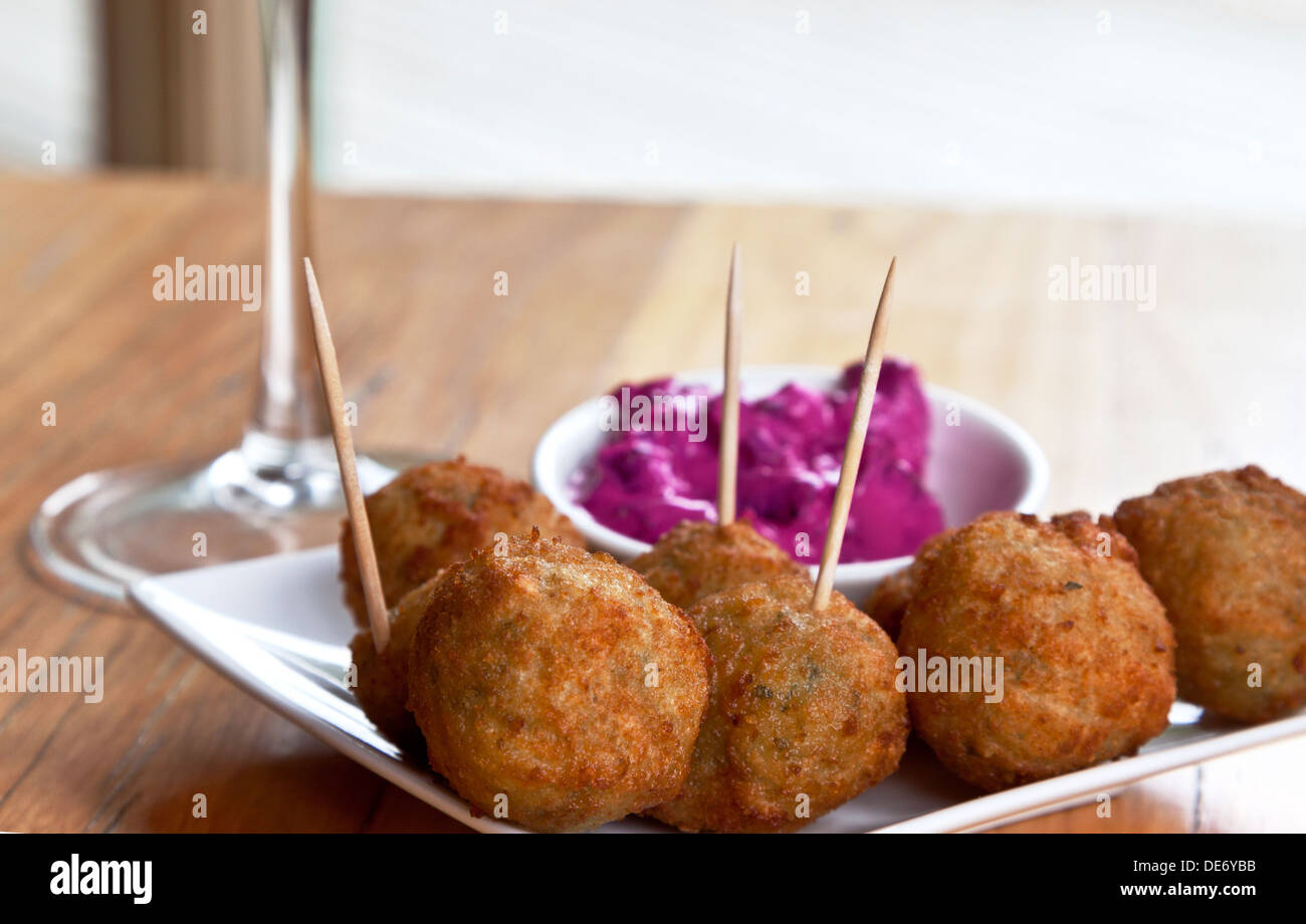 Fried hummus balls as appetizers with beet root dip; location is on ...