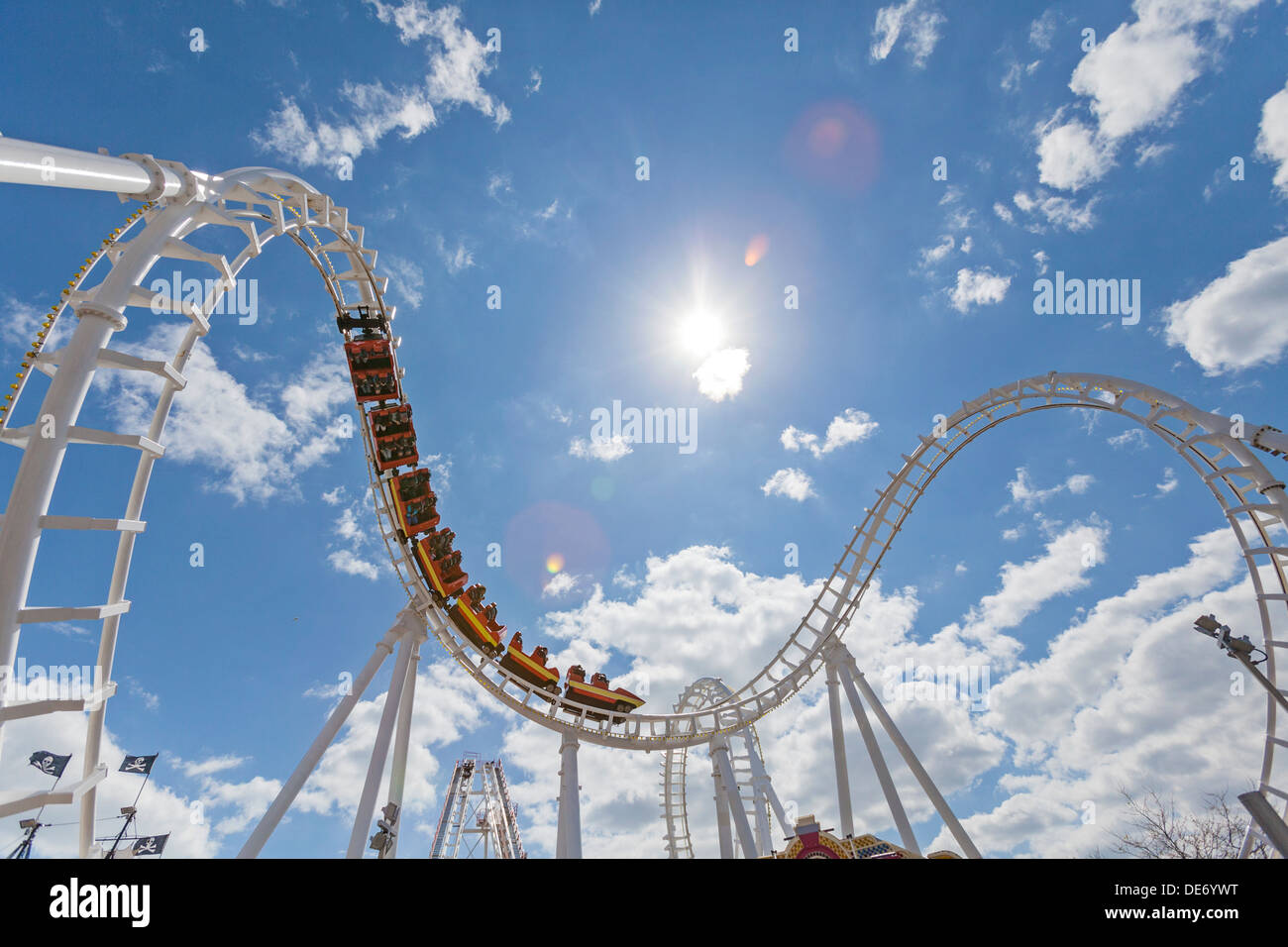 A roller coaster with riders in an amusement park Stock Photo - Alamy