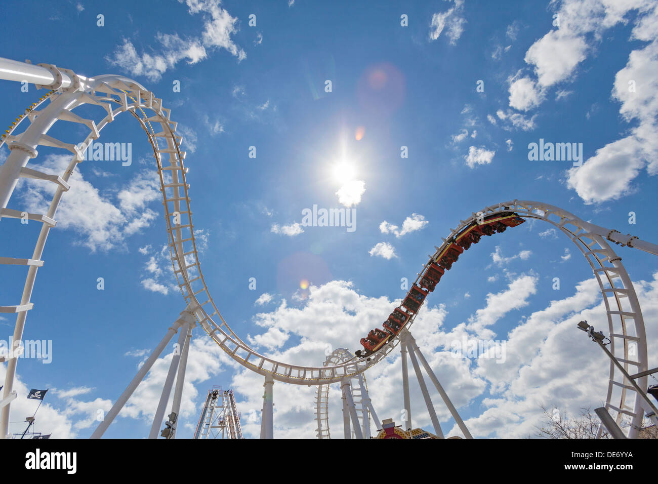 A roller coaster with riders in an amusement park Stock Photo - Alamy