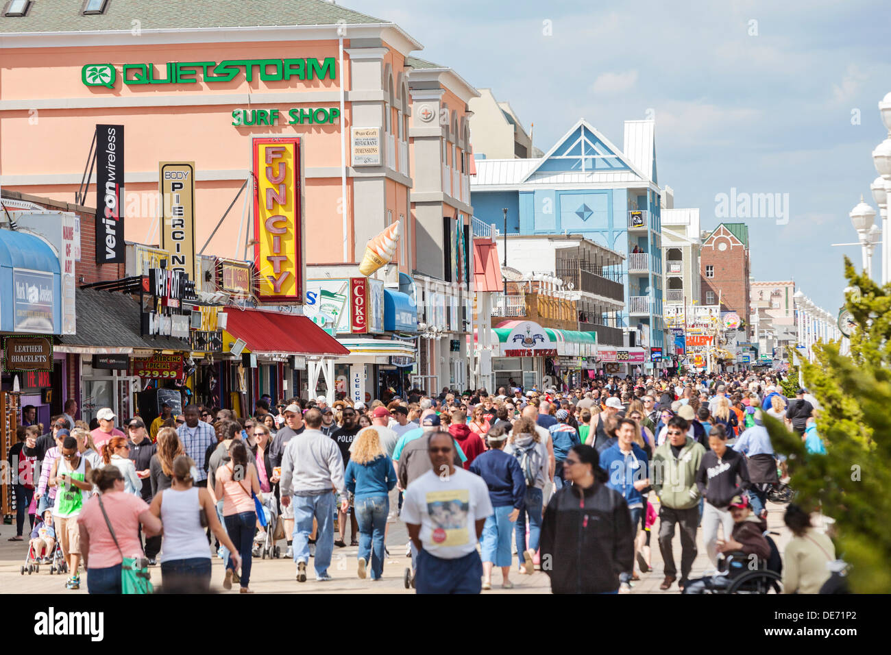 An ocean boardwalk with people, places to eat food and games of chance ...