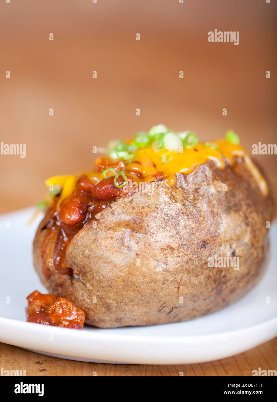 Loaded baked potato with chili and cheese on a plate Stock Photo - Alamy