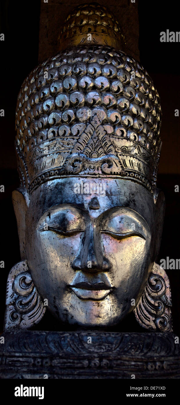 exotic silver mask of a face with ornate headdress on a dark background ...