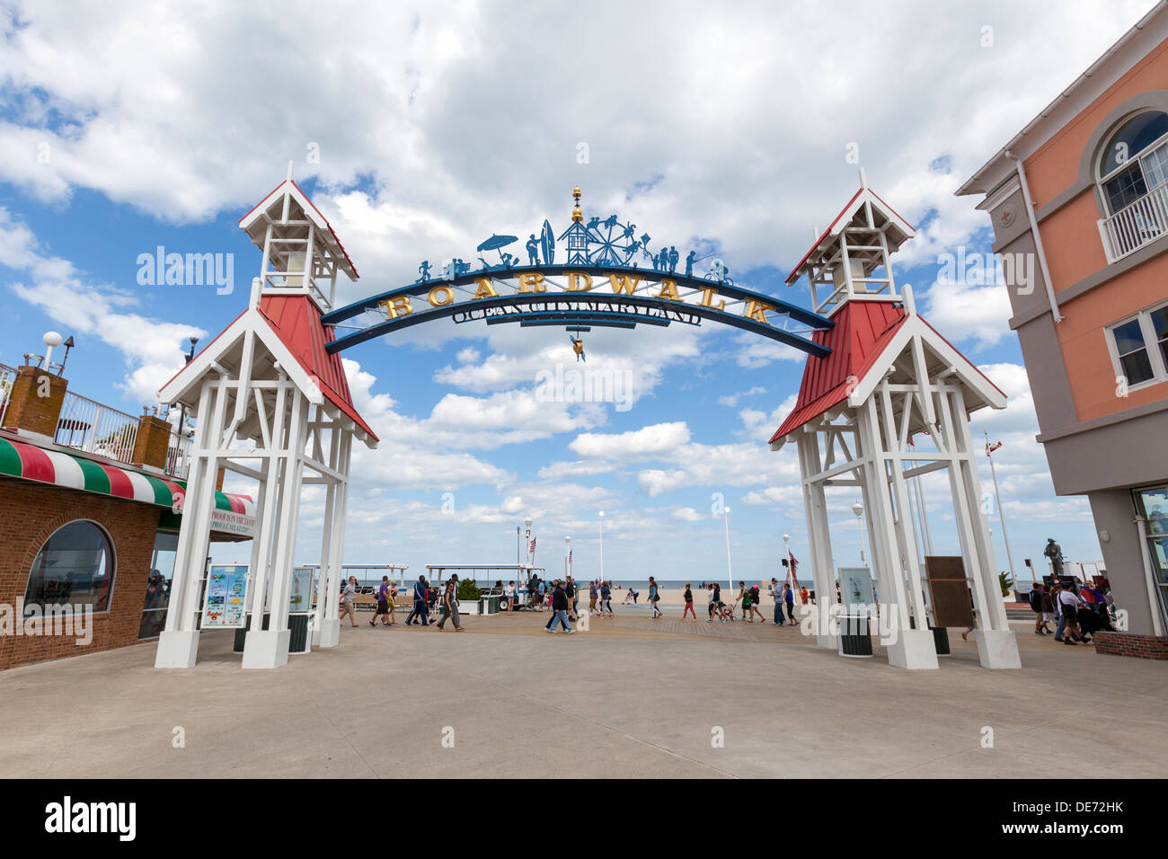 An ocean boardwalk with people, places to eat food and games of chance ...