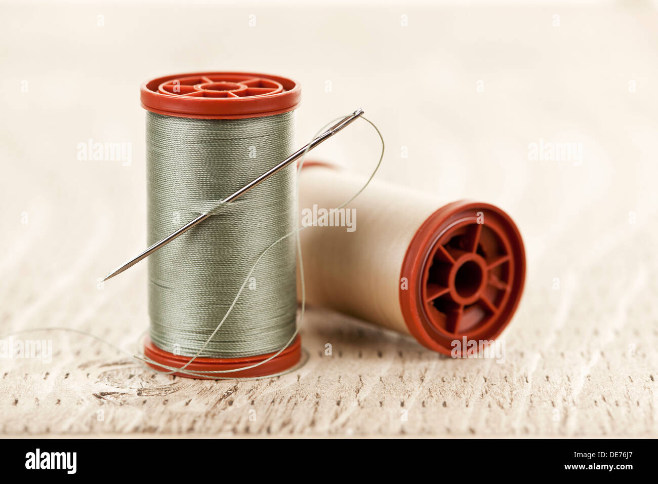 Two spools of thread with needle for sewing Stock Photo - Alamy