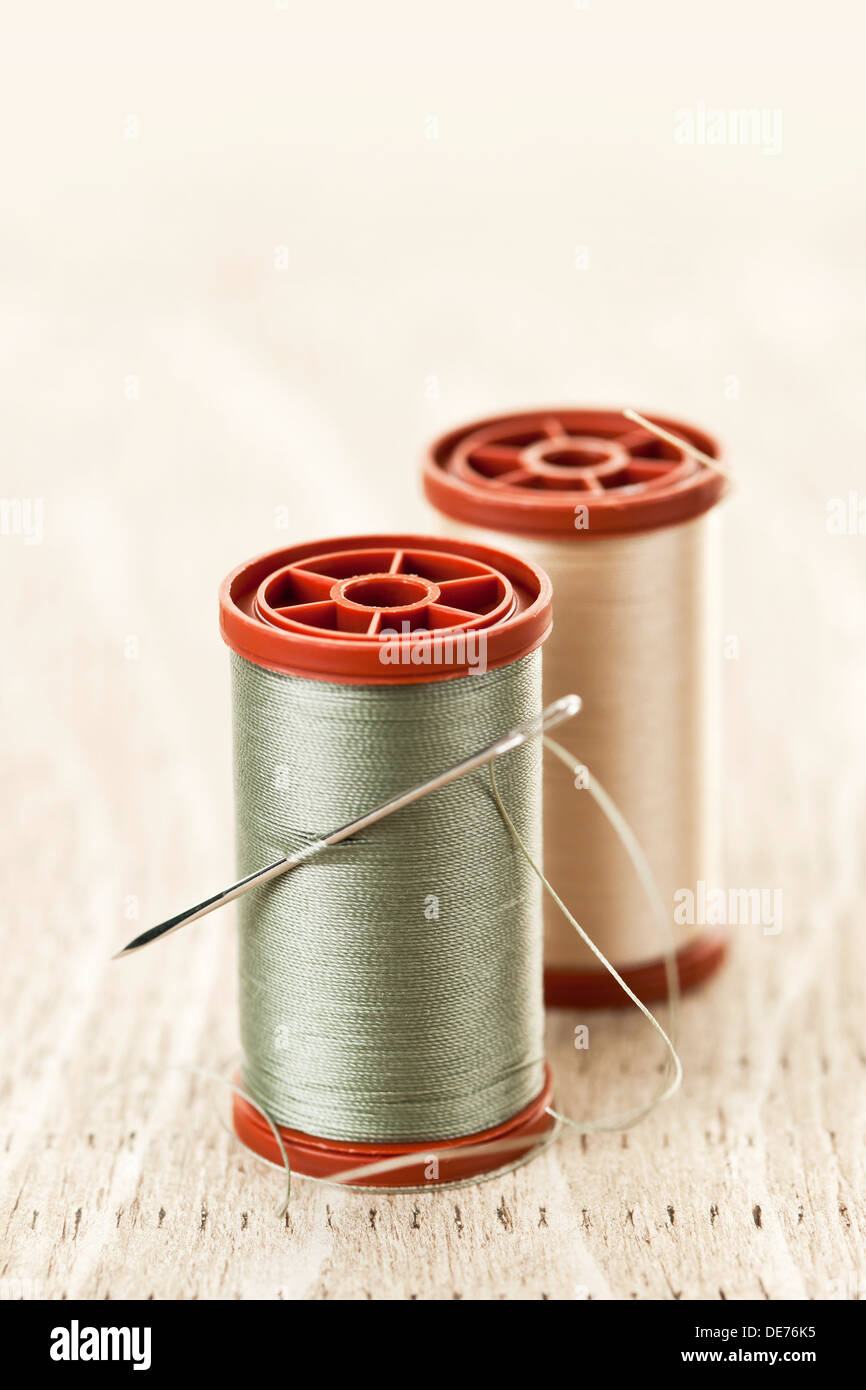 Two spools of thread with needle for sewing Stock Photo - Alamy