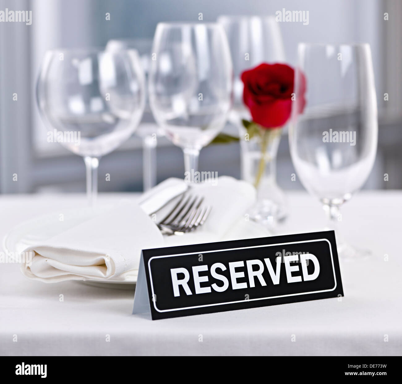 Reserved romantic restaurant table setting with roses plates and ...