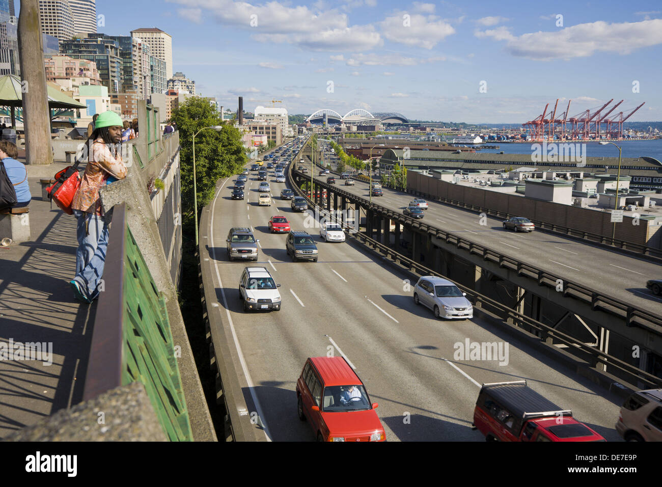 Black man watches traffic on highway 99 below along waterfront area of ...