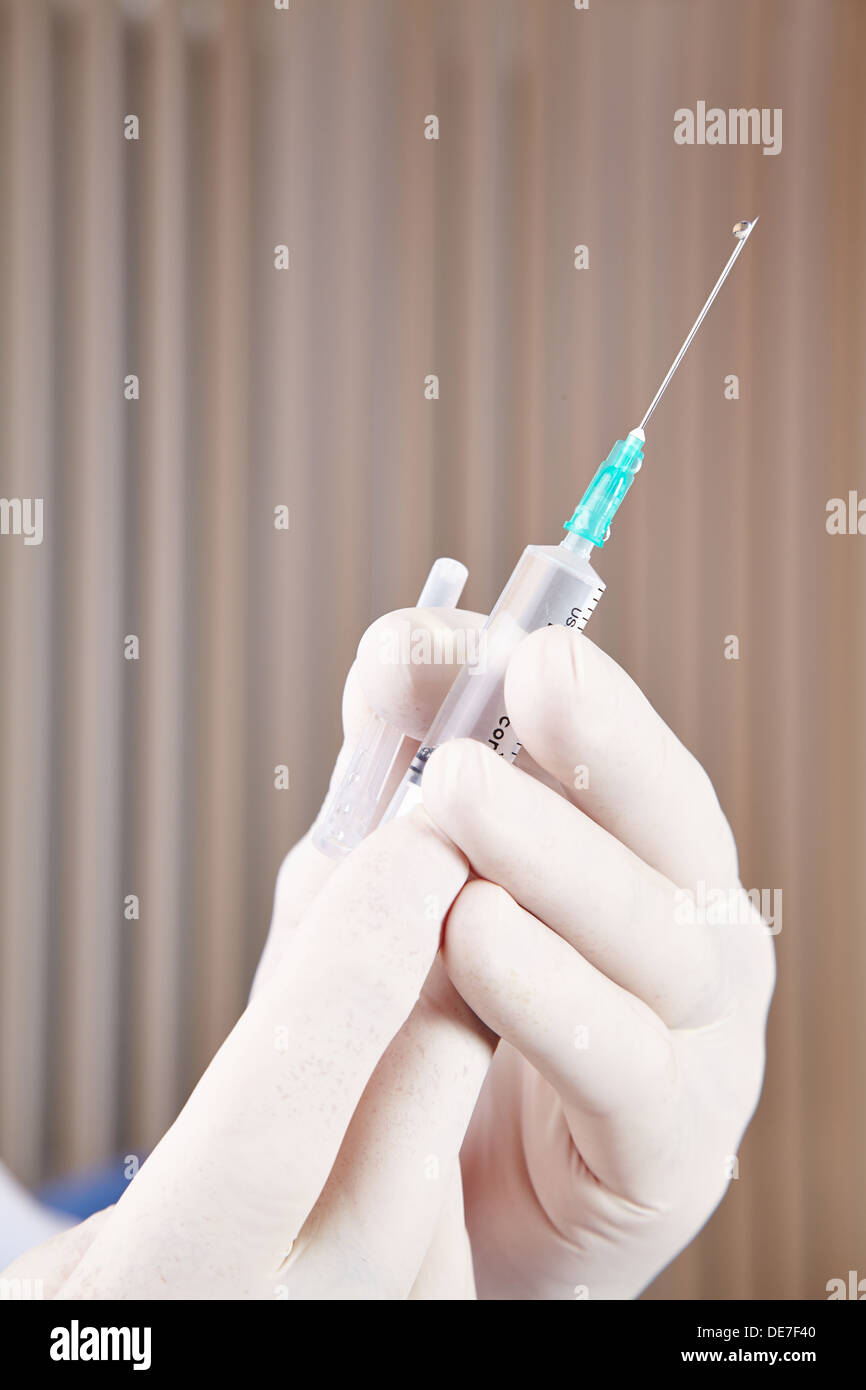 Nurse preparing syringe for injection for an immunization Stock Photo ...