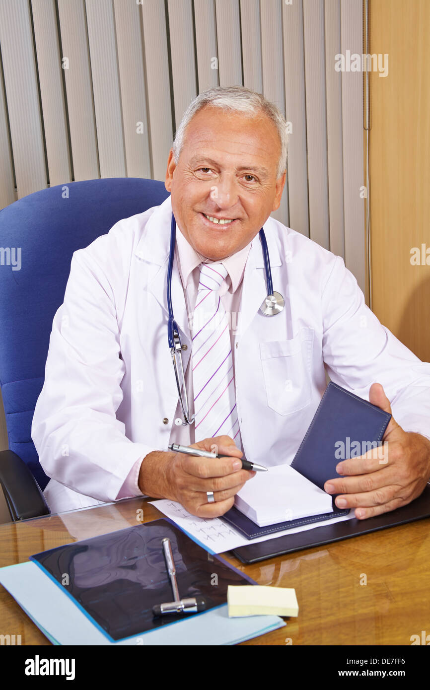 Senior doctor taking notes in his hospital office Stock Photo - Alamy