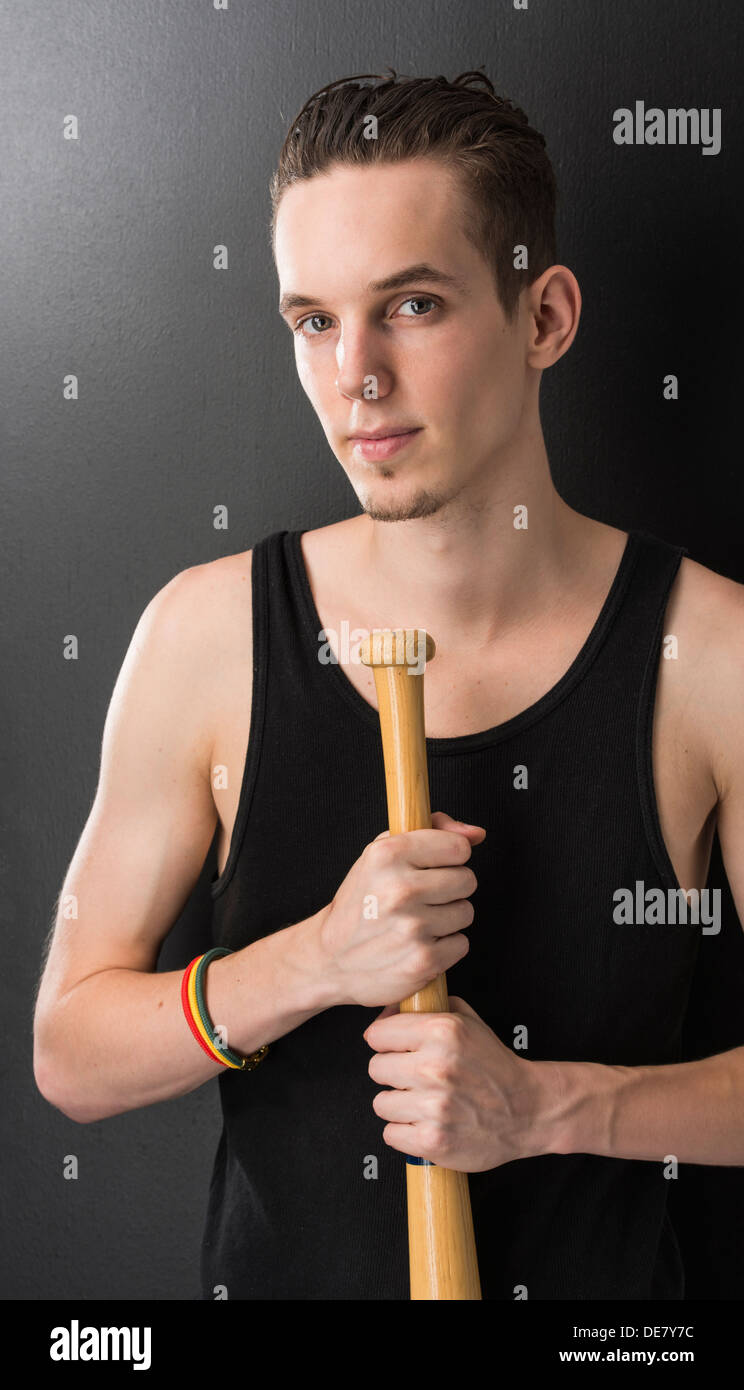 Portrait of handsome young man holding a baseball bat Stock Photo - Alamy