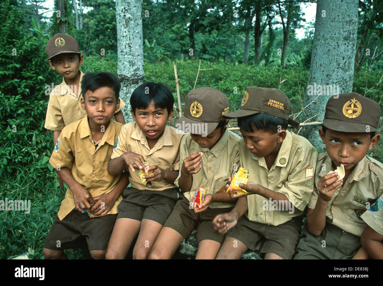 SCHOOLCHILDREN EATING SNACKS IN A VILLAGE IN EAST JAVA, INDONESIA Stock ...
