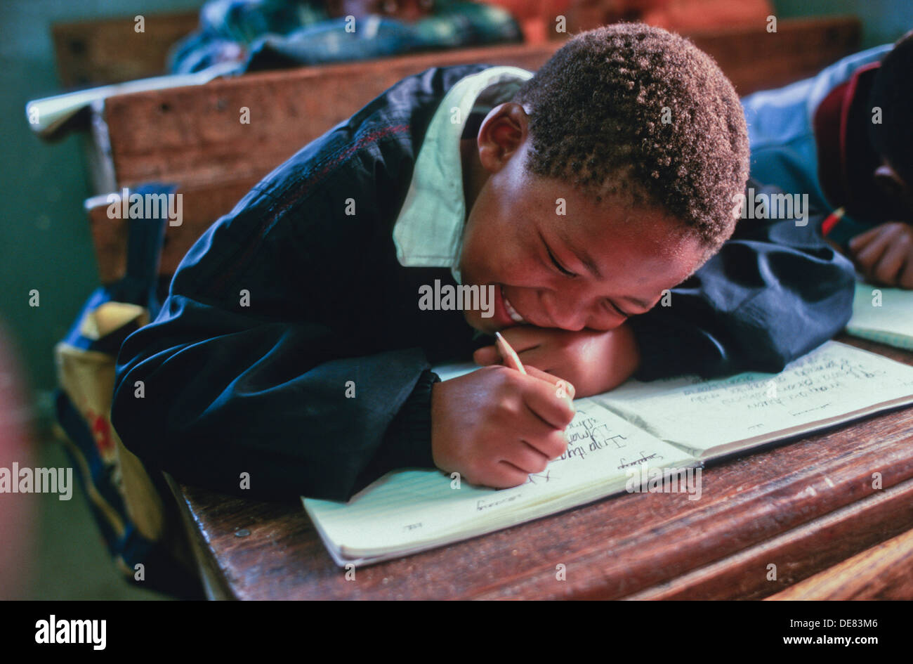 Boy writing at a classroom in a school in Alexandra township, Cape Town ...