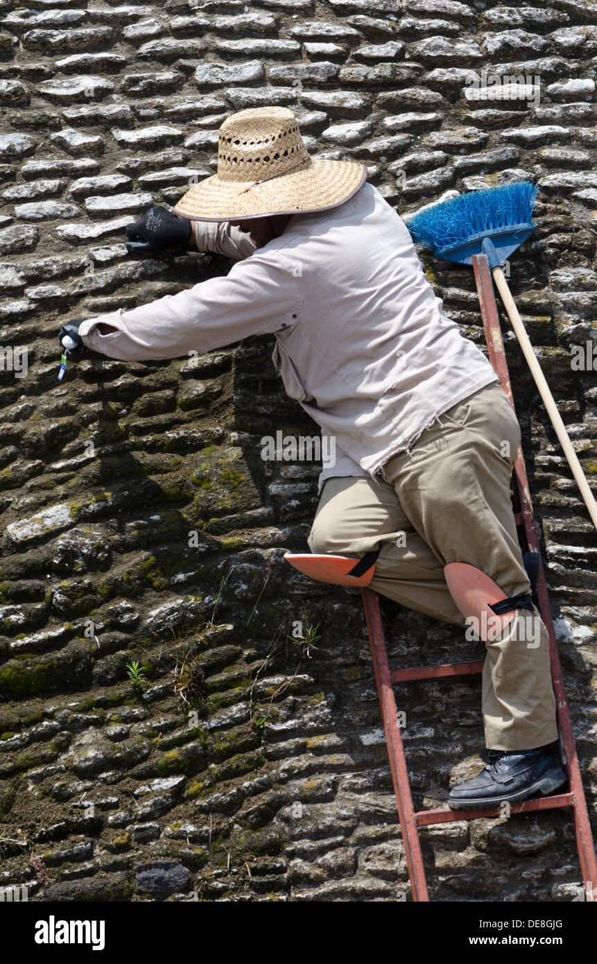 A worker on a ladder cleaning the brickwork of part of the Great ...