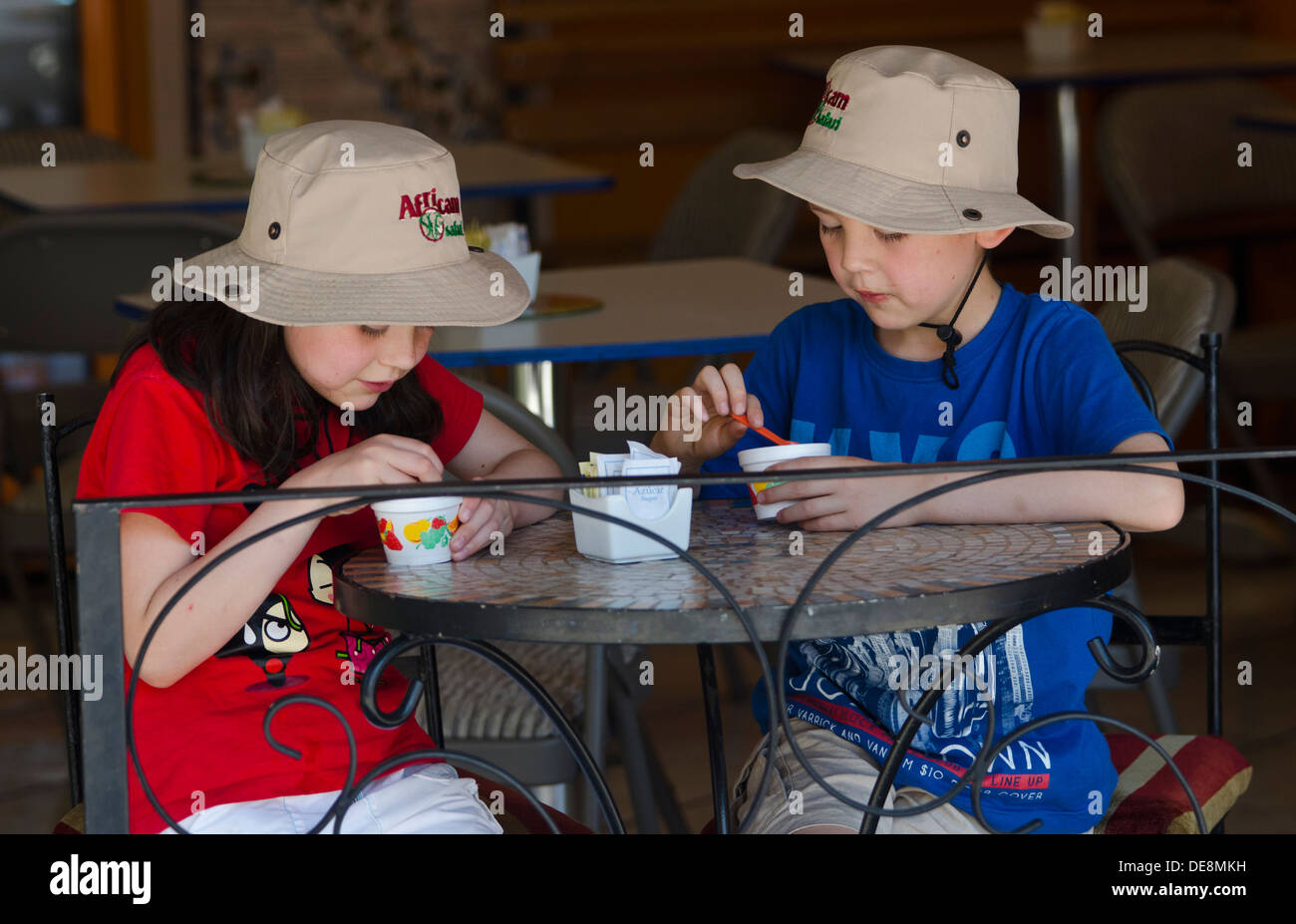 Two young children eating gelato or ice cream in a gelateria in ...