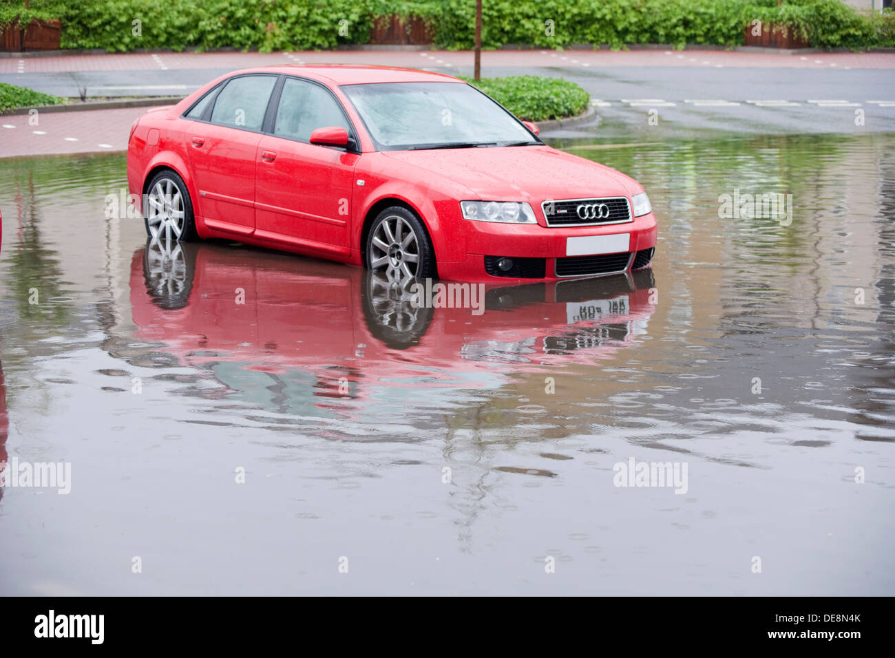 Red car sitting in a flooded car park Stock Photo - Alamy